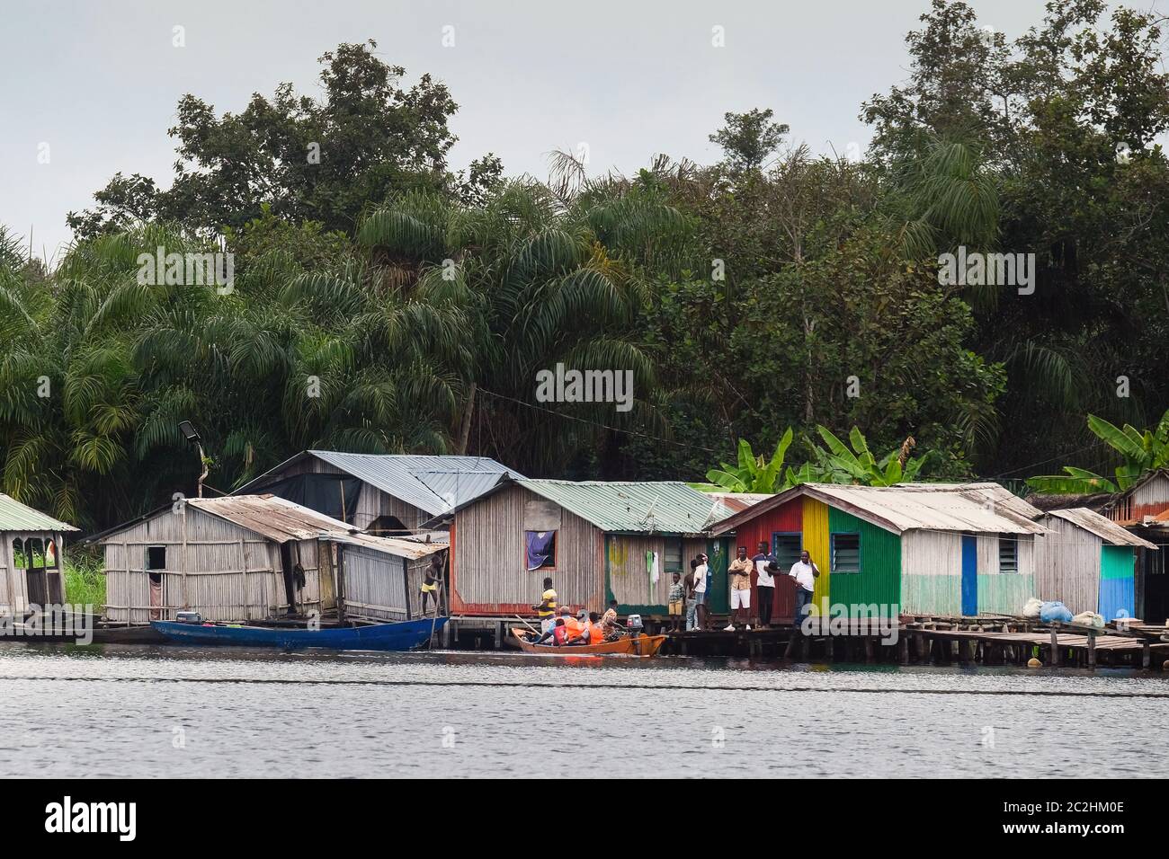 Boat in front of the huts of the stilt village Nzulezo in Lake Amansura ...