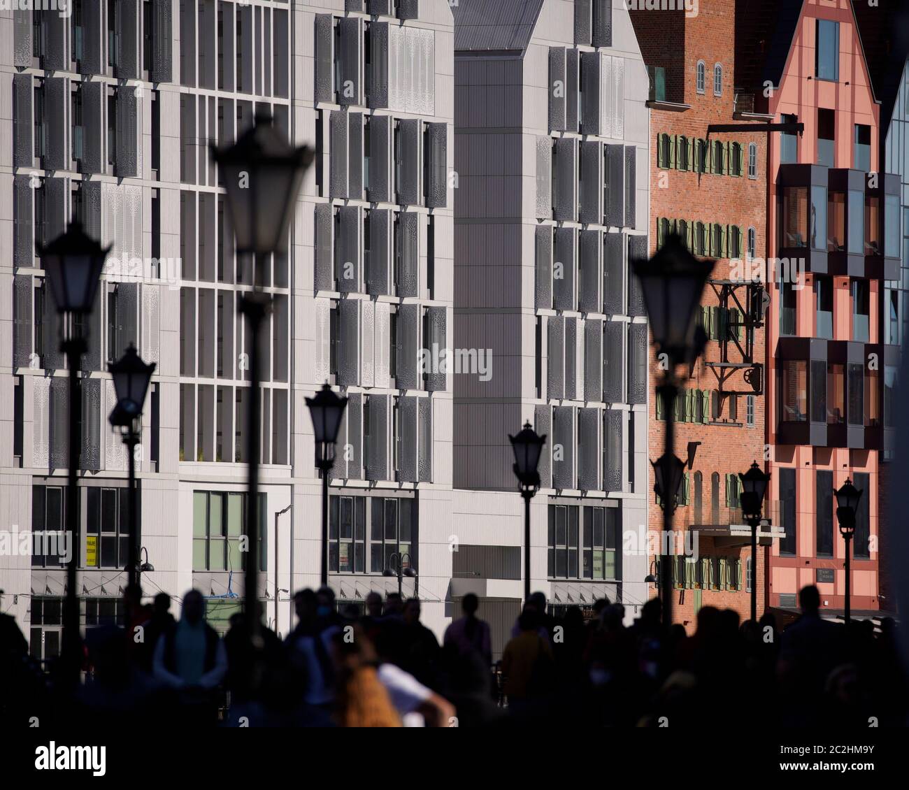 People are seen in the city center with modern buildings resembling the ...