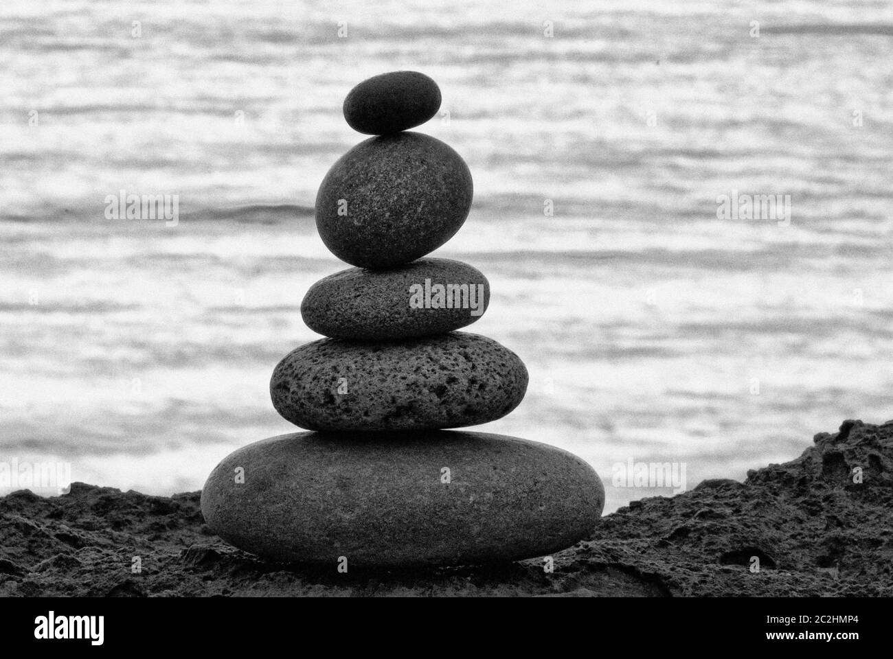Black and white image of stack of balanced pebble at the beach with the ...
