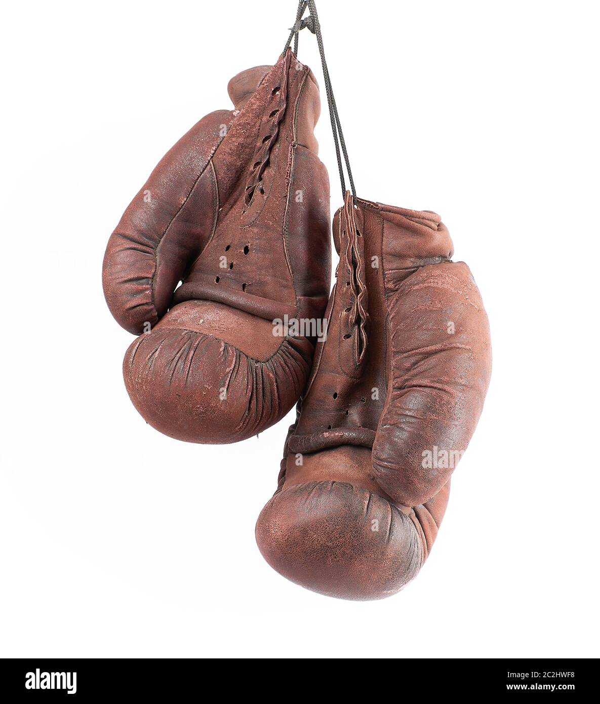 pair of very old vintage brown leather boxing gloves hanging on a black ...