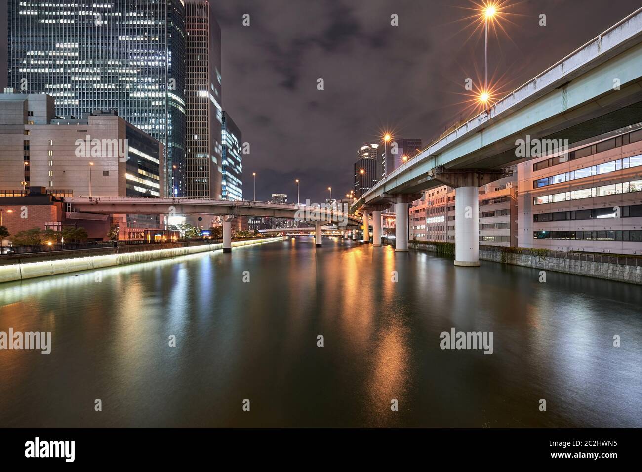Osaka night scene, urban expressway bridges over the river in downtown ...