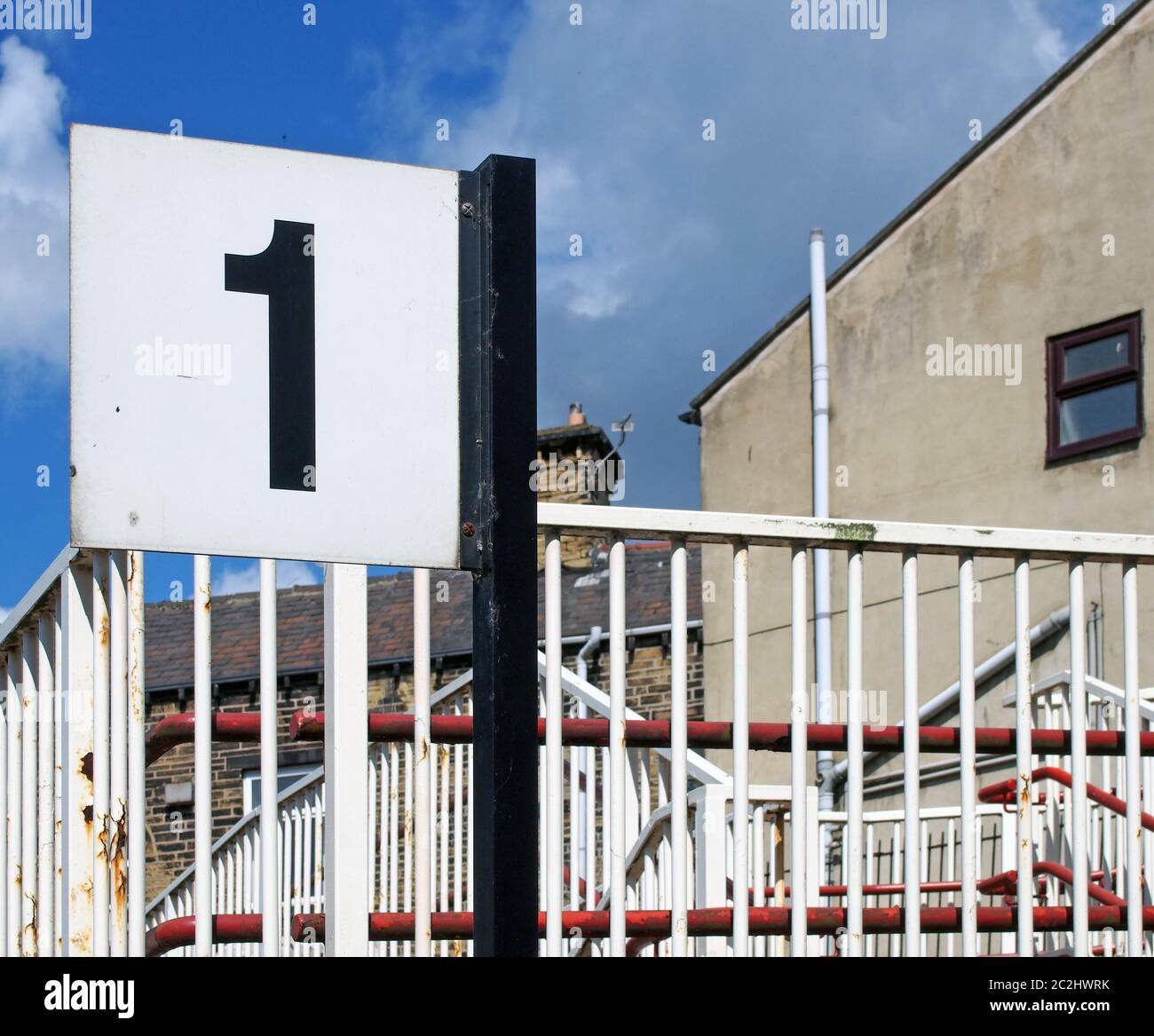 a railway station platform sign with the number 1 next to shabby ...