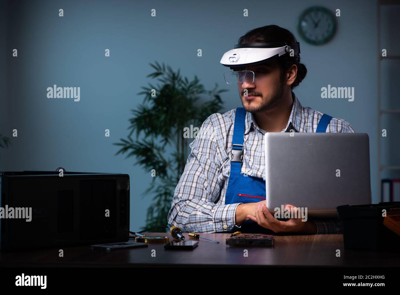 Young technician repairing computer in workshop at night Stock Photo ...