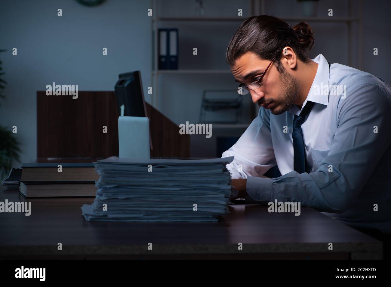 Young employee working in the office night time Stock Photo - Alamy