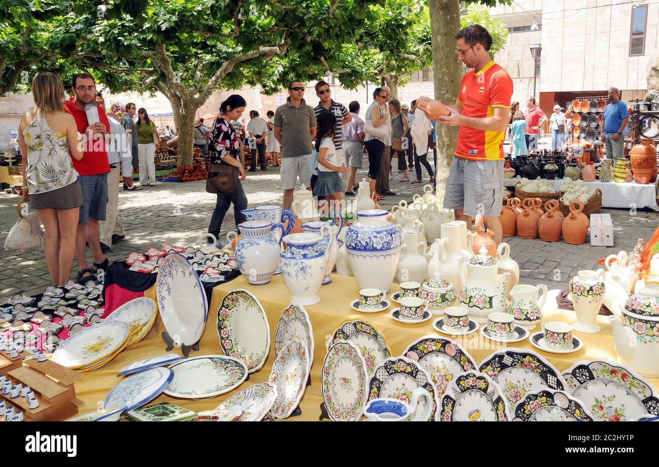 Porcelain vessels and dishes at an outdoor ceramic craft fair in a ...