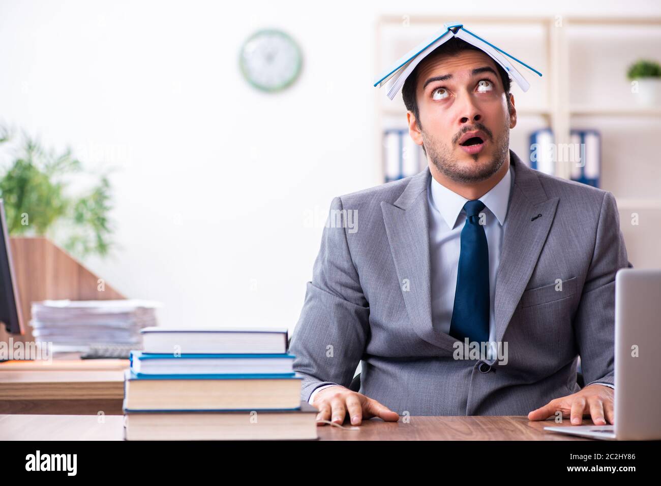 Young businessman reading books at workplace Stock Photo - Alamy