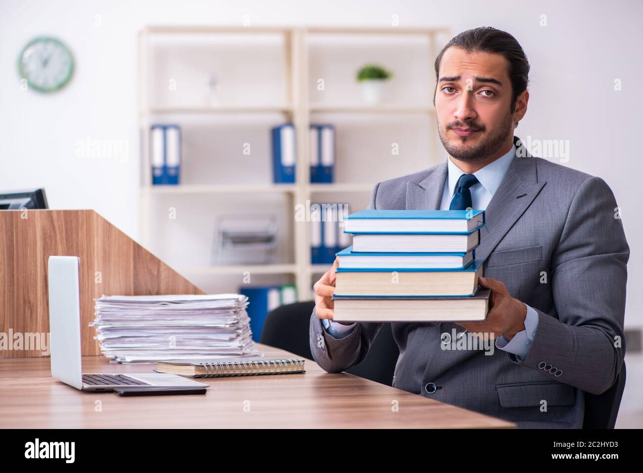 Young businessman reading books at workplace Stock Photo - Alamy