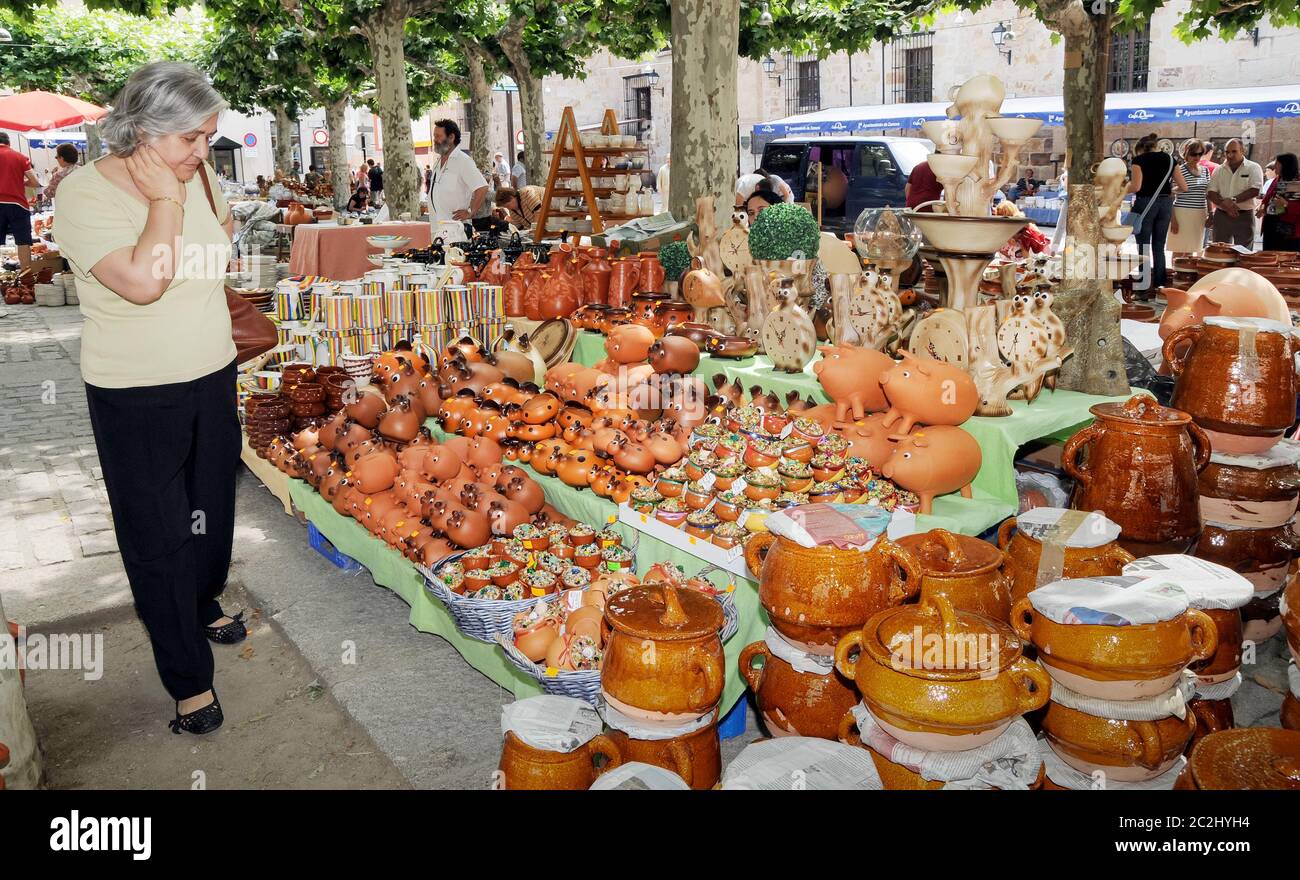 Piggy banks in the shape of pigs along with other ceramic pots at a ...
