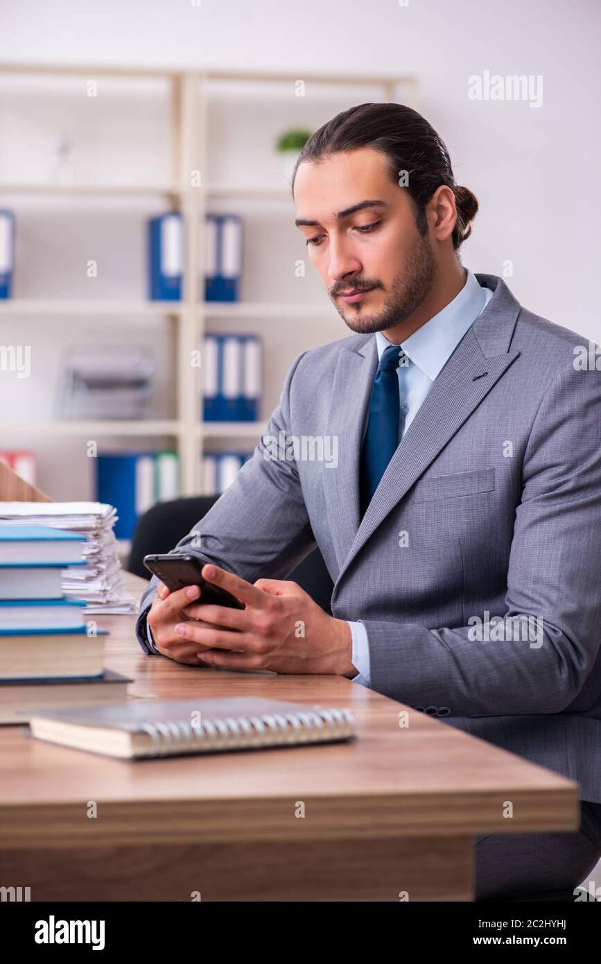 Young businessman reading books at workplace Stock Photo - Alamy