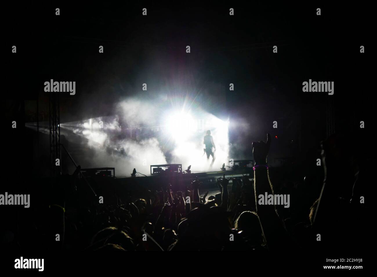 Crowd in front a metal concert in very dark scene with light pointing ...