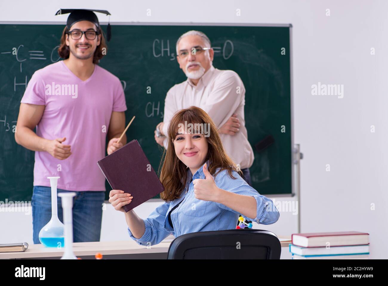 Old teacher and two students in the classroom Stock Photo - Alamy