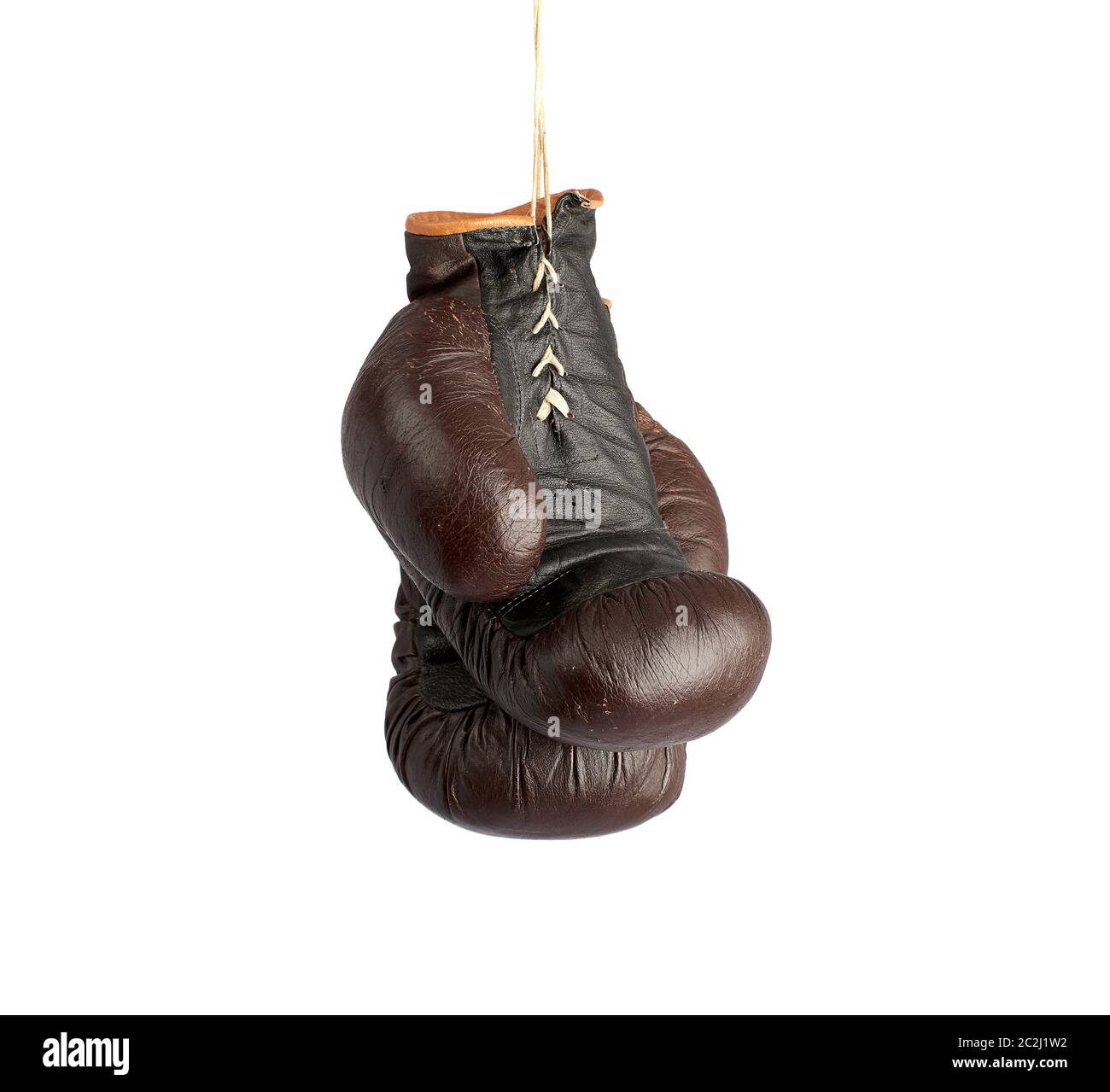 pair of very old vintage brown leather boxing gloves hanging on a rope ...