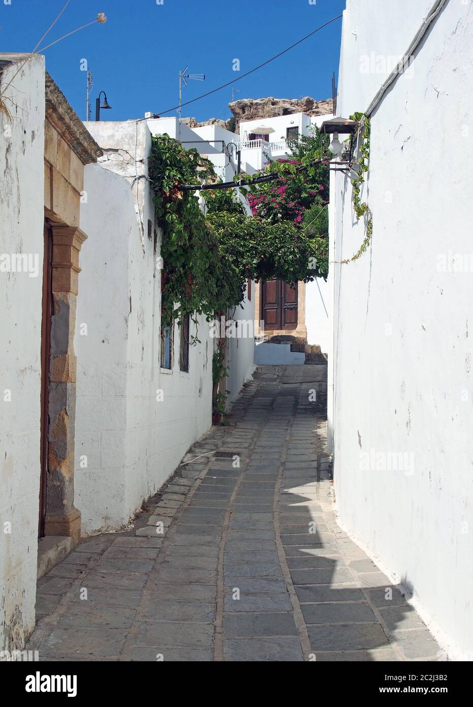 quiet narrow typical winding narrow alley in rhodes town with white ...