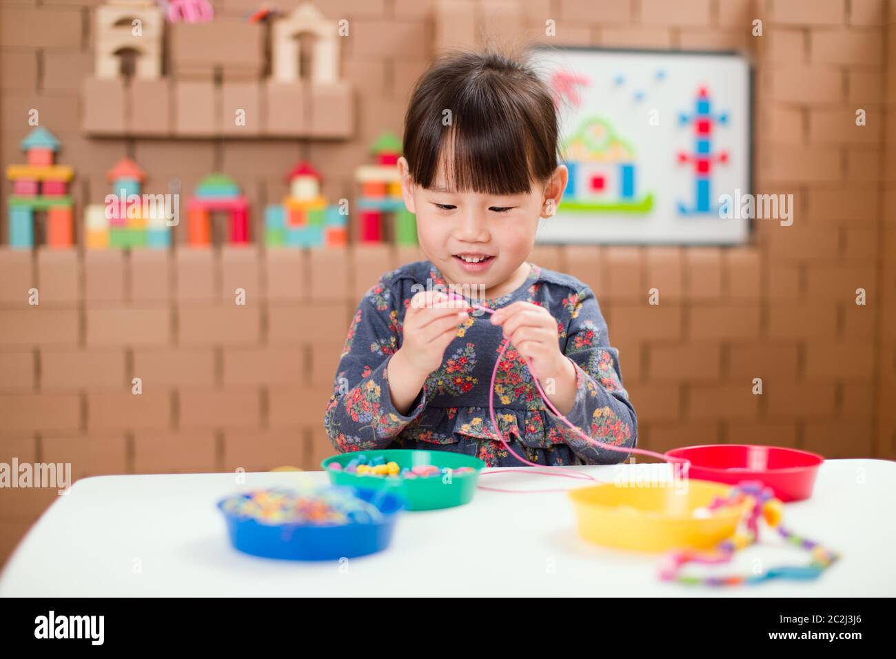 toddler girl string wooden bead crafts for homeschooling Stock Photo ...