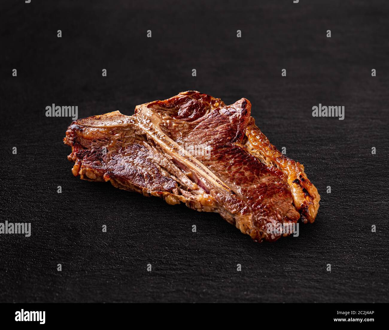 Argentinian beef T-bone steak on black background Stock Photo - Alamy
