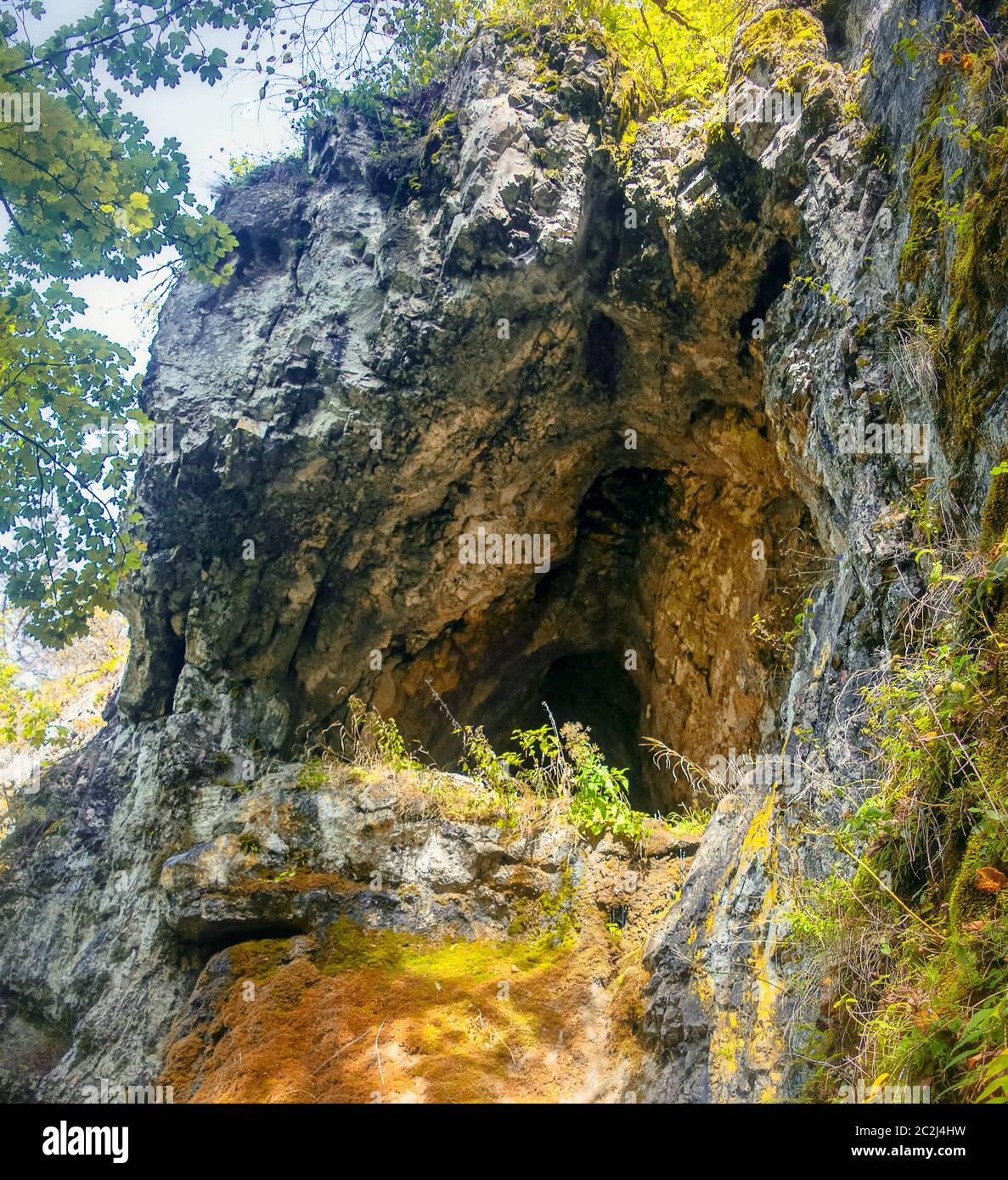 Cave entrance in the mountain Stock Photo - Alamy