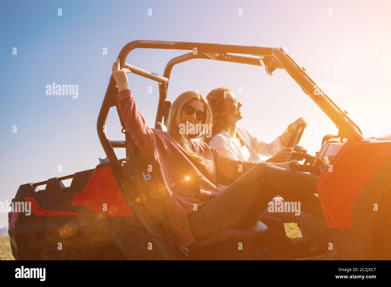 two young women driving a off road buggy car Stock Photo - Alamy
