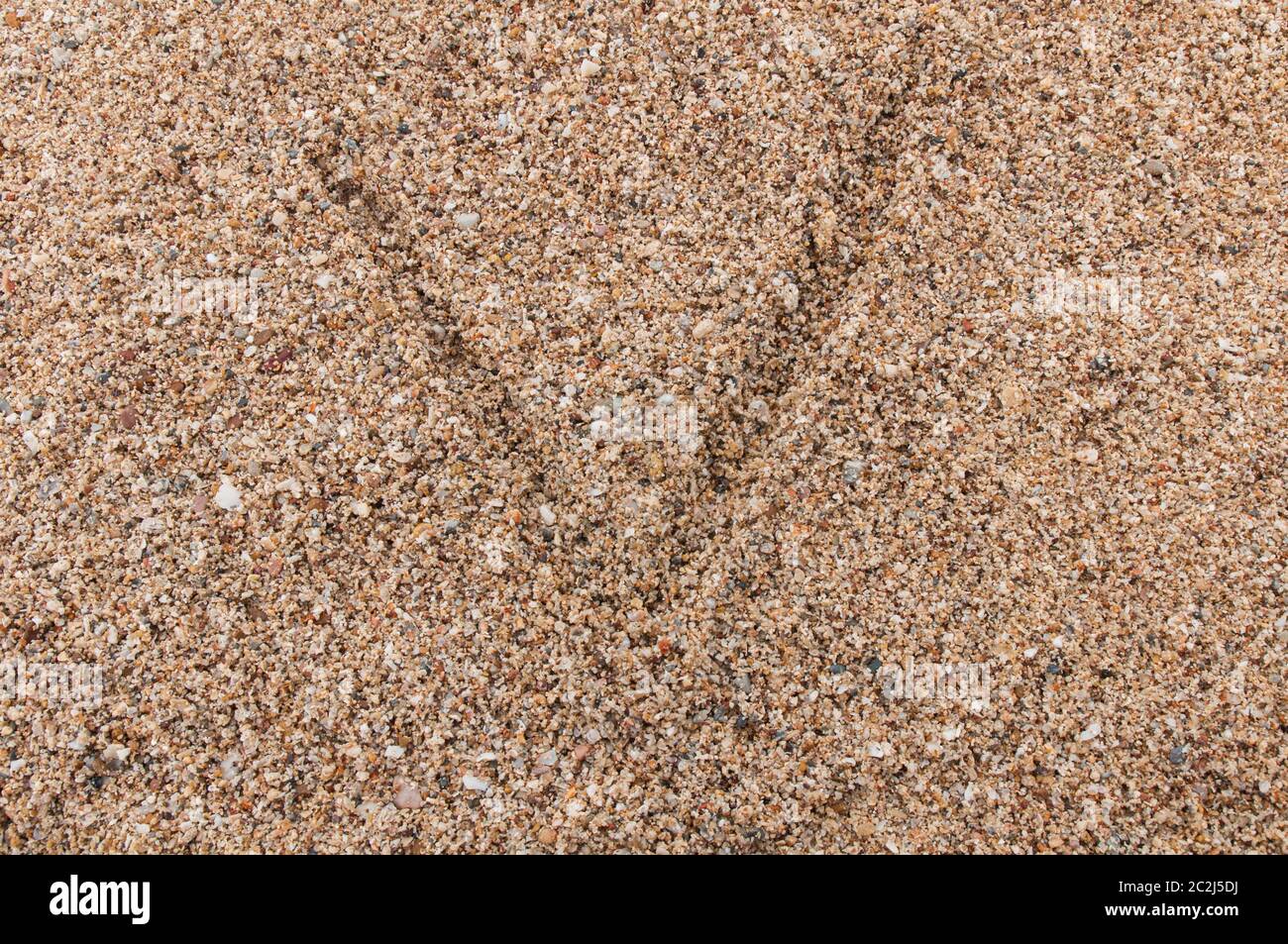 Character V of the alphabet writing on the sand Stock Photo - Alamy