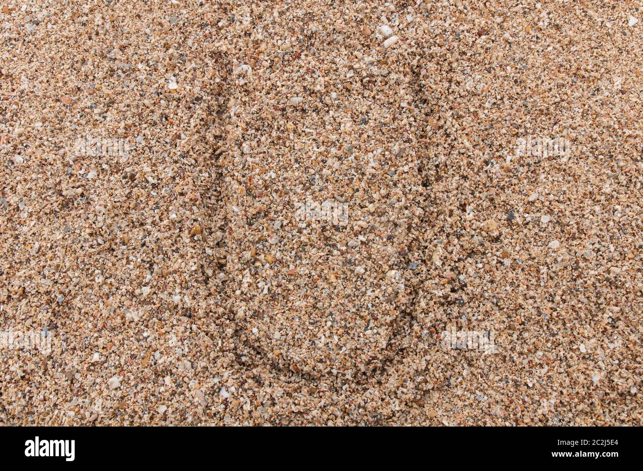 Character U of the alphabet writing on the sand Stock Photo - Alamy