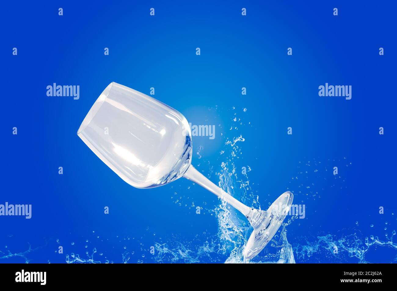 Wine glass fall in the water with a blue background Stock Photo - Alamy