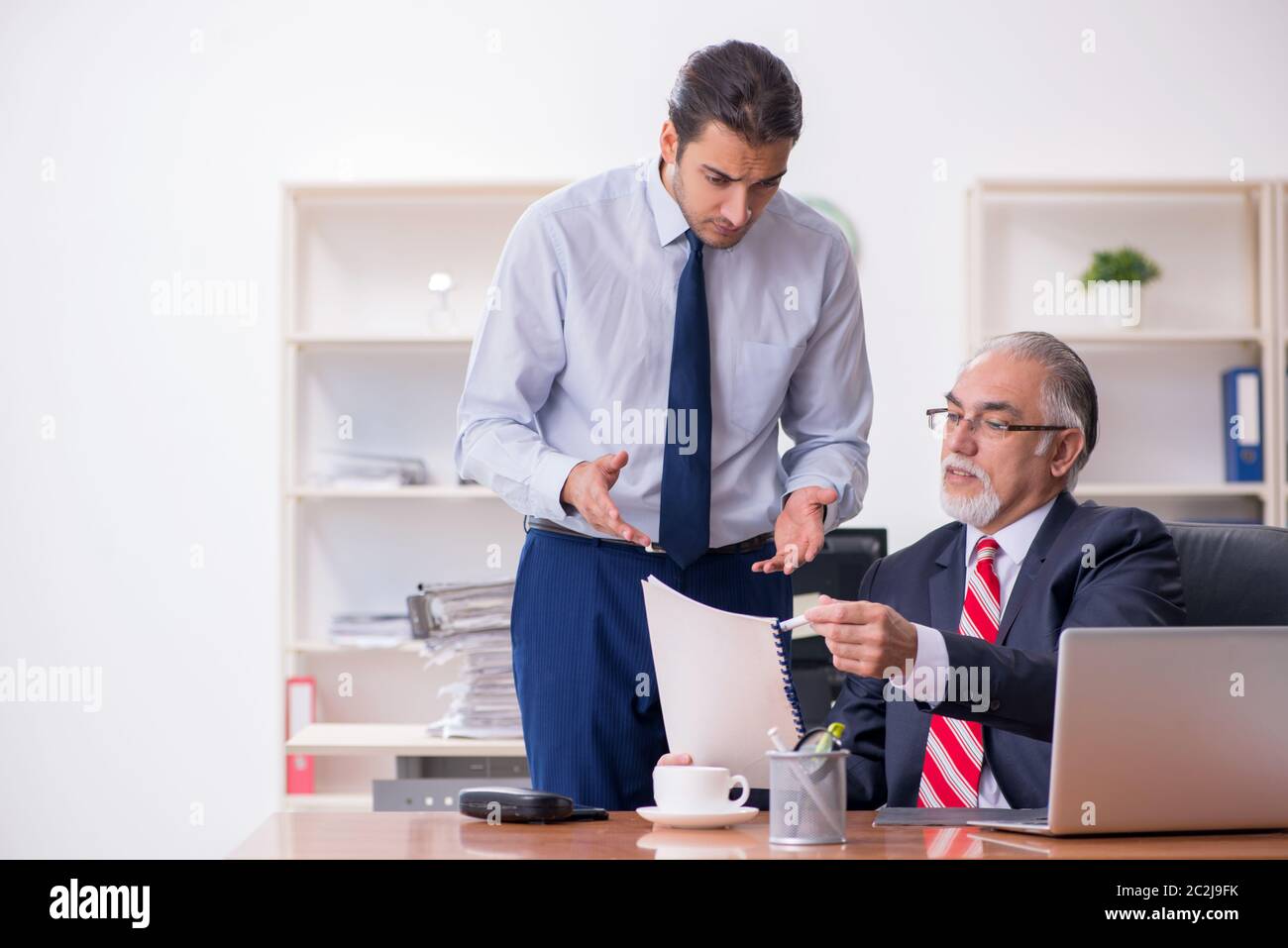 Old boss and young employee in the office Stock Photo - Alamy