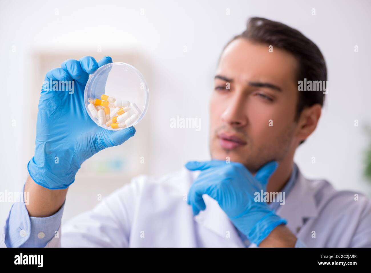 Young male lab assistant in the drug synthesis concept Stock Photo - Alamy