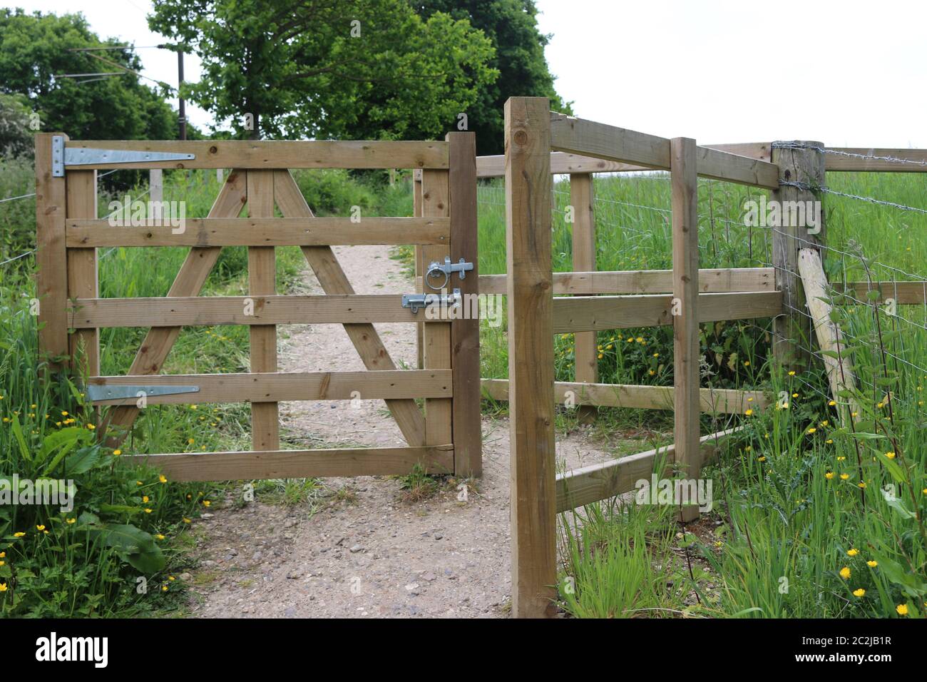 Gate in a new wooden post and rail fence with pedestrian access to the ...