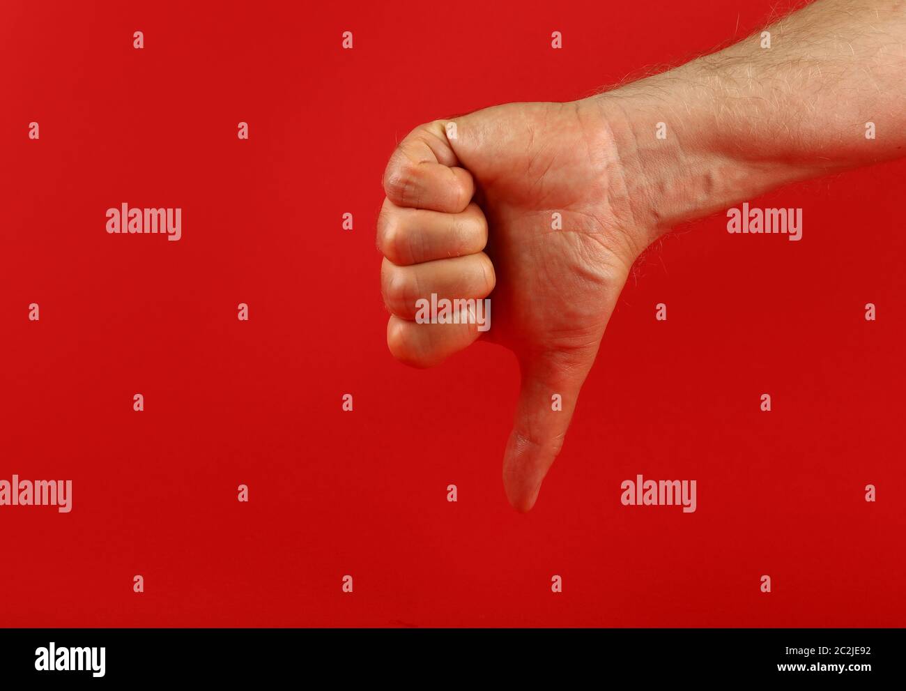 Man hand shoving thumb down, dislike, bad gesture over red background ...