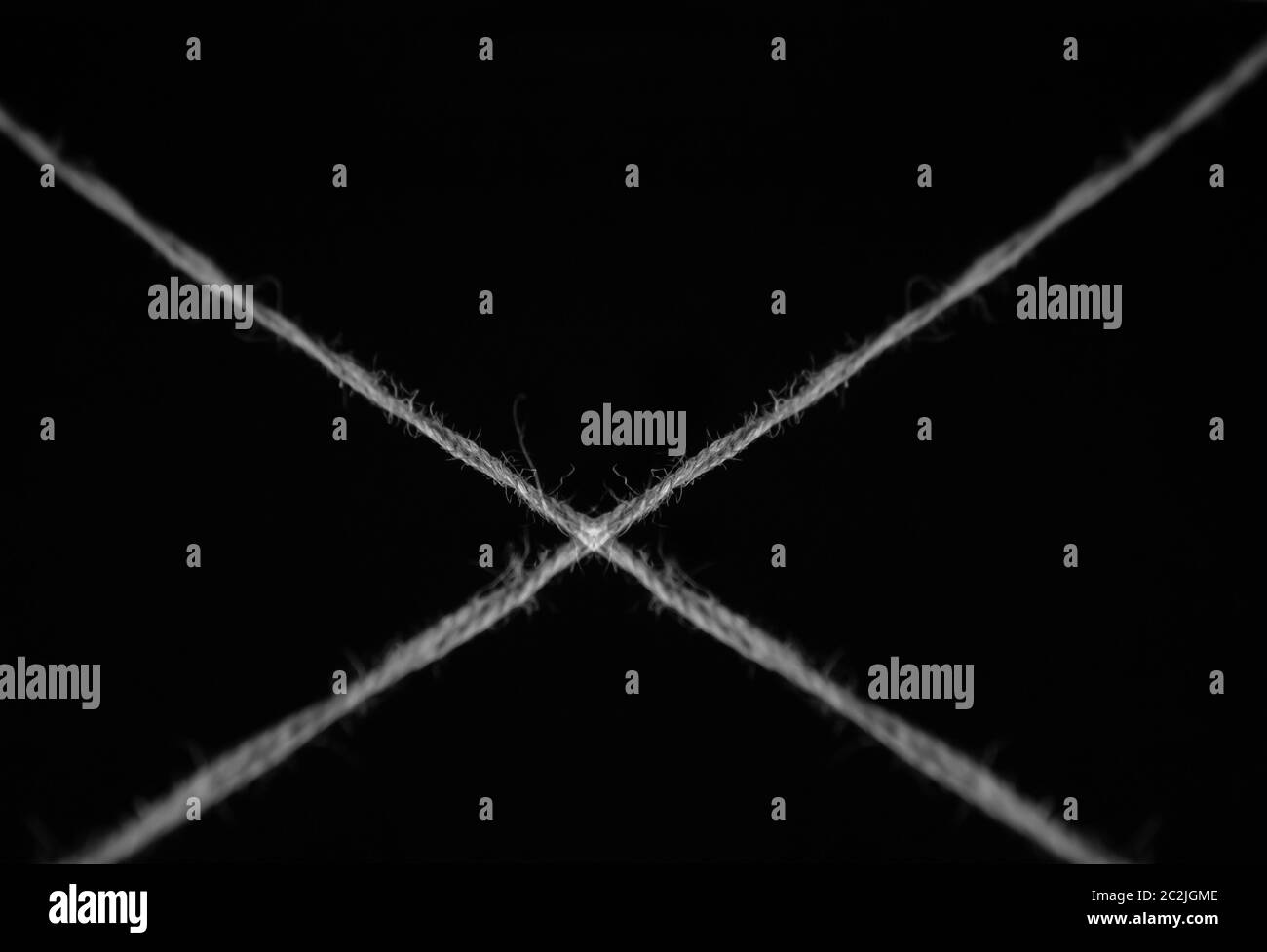 Crossed strings on the black background Stock Photo - Alamy