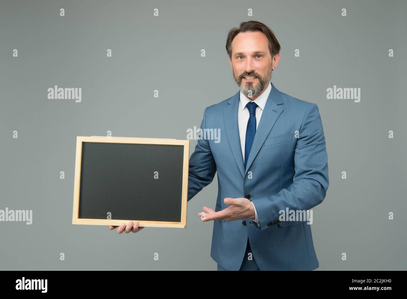 Product introduction. Businessman presenting product at blackboard ...