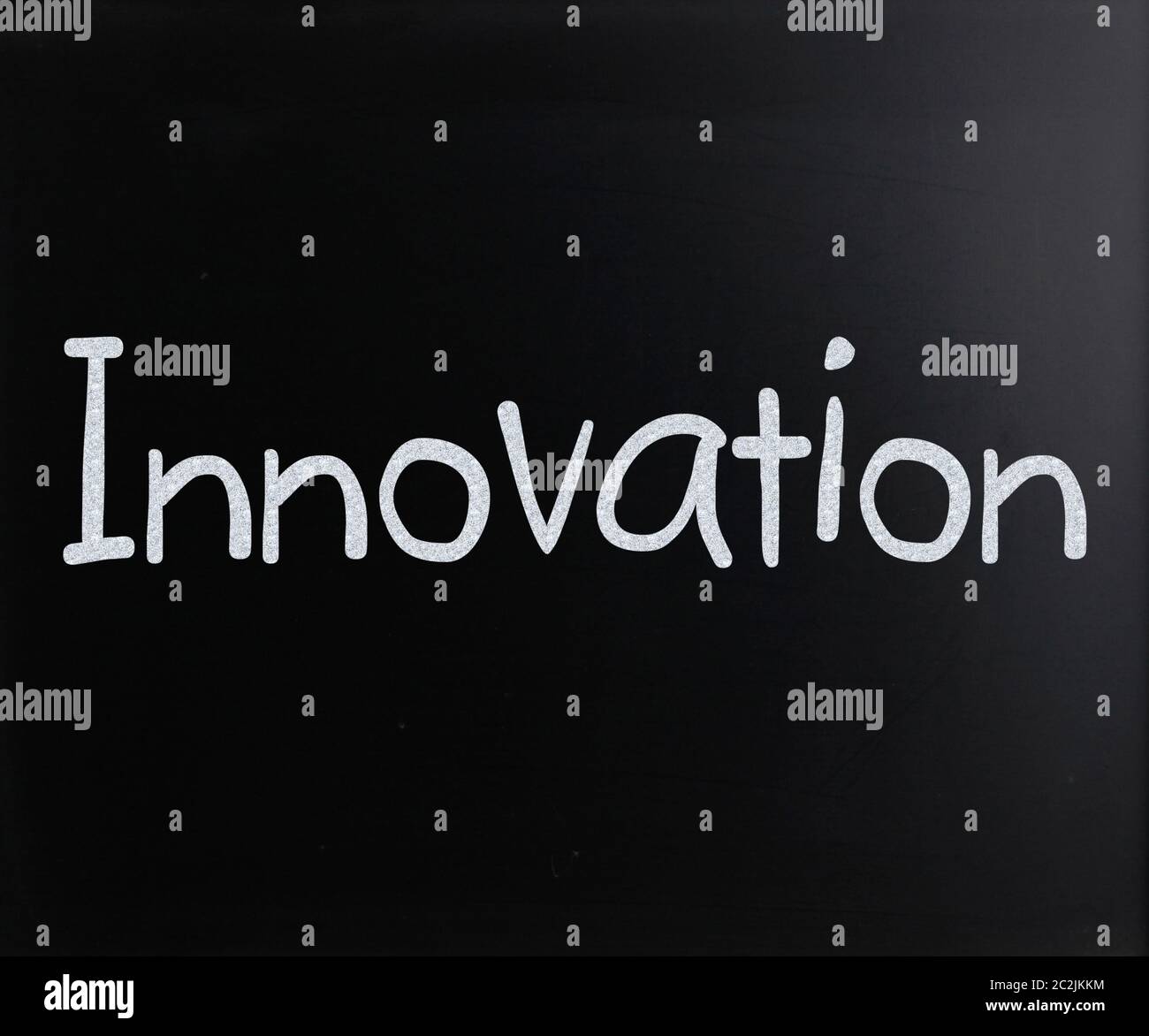 The word "Innovation" handwritten with white chalk on a blackboard ...