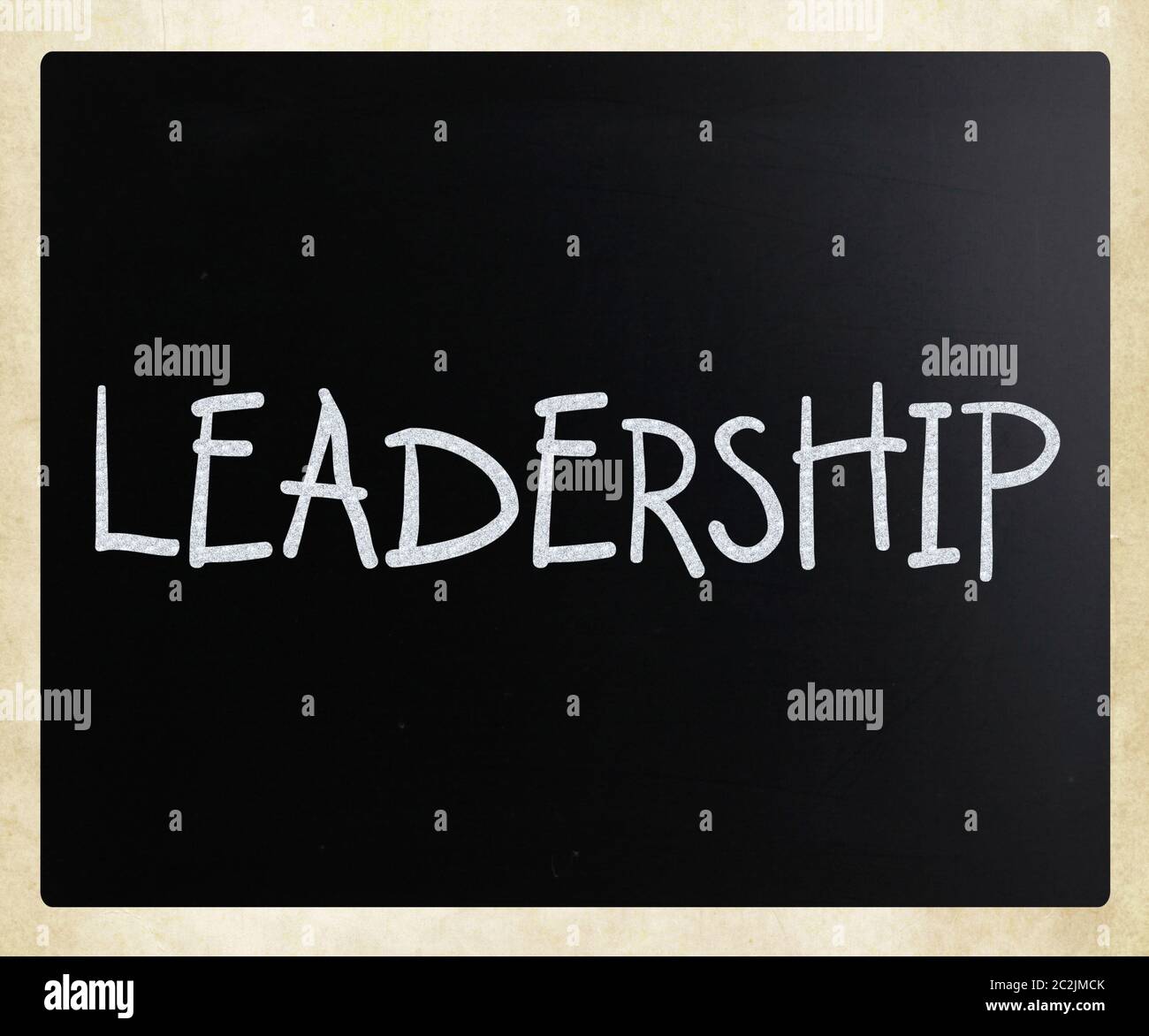 The word "Leadership" handwritten with white chalk on a blackboard ...