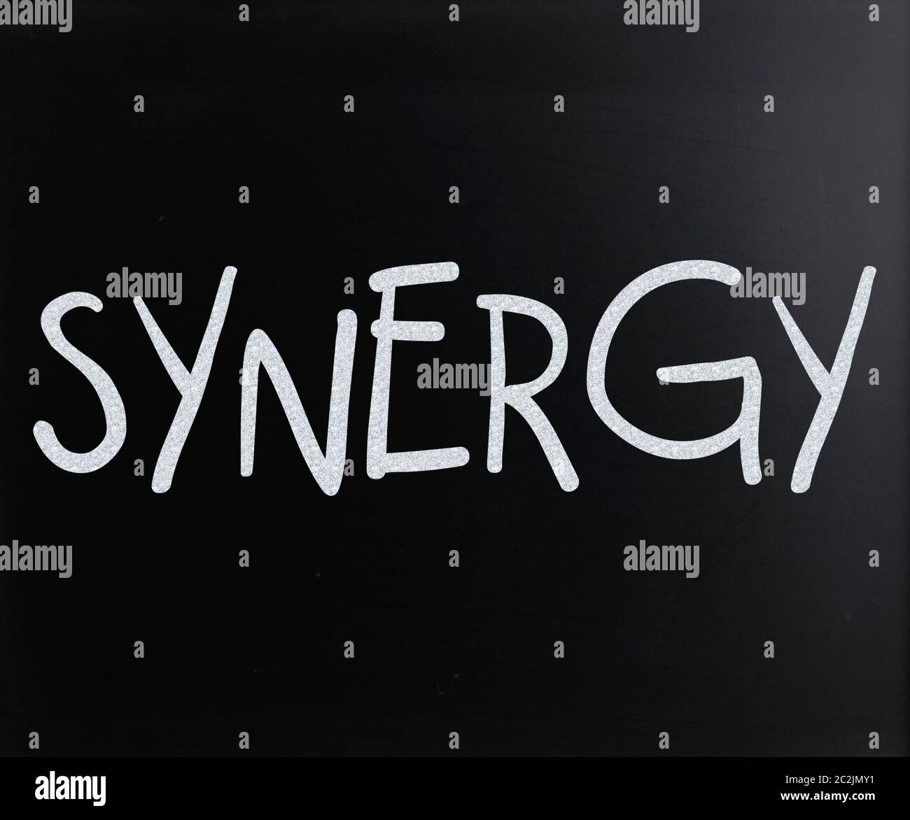 The word "Synergy" handwritten with white chalk on a blackboard Stock ...