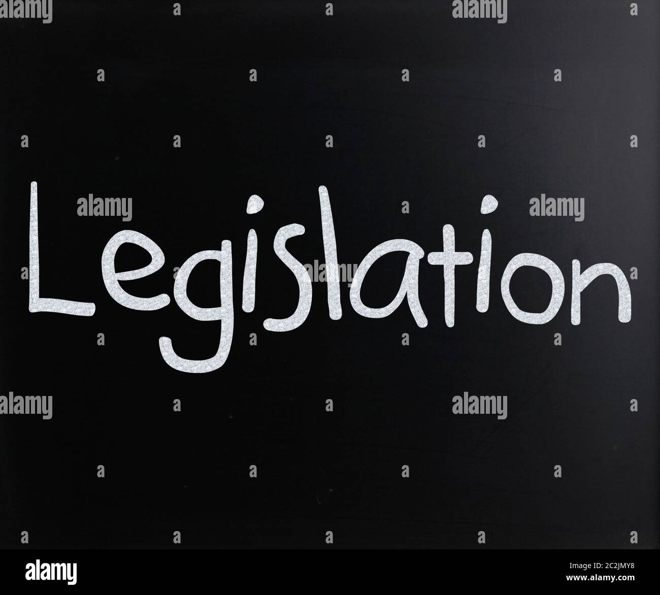 The word "Legislation" handwritten with white chalk on a blackboard ...