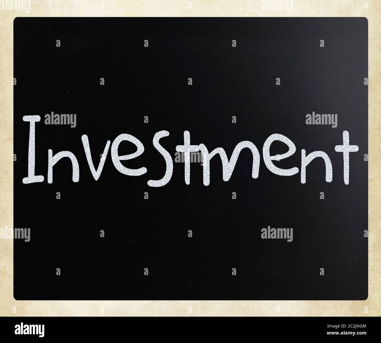 The word 'Investment' handwritten with white chalk on a blackboard ...
