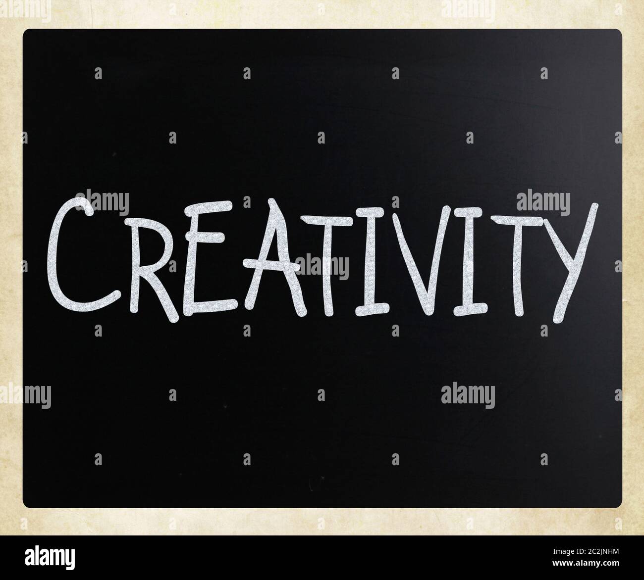 The word "Creativity" handwritten with white chalk on a blackboard ...