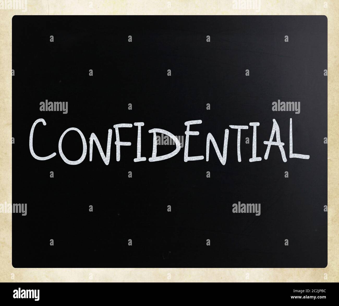 The word "Confidential" handwritten with white chalk on a blackboard ...