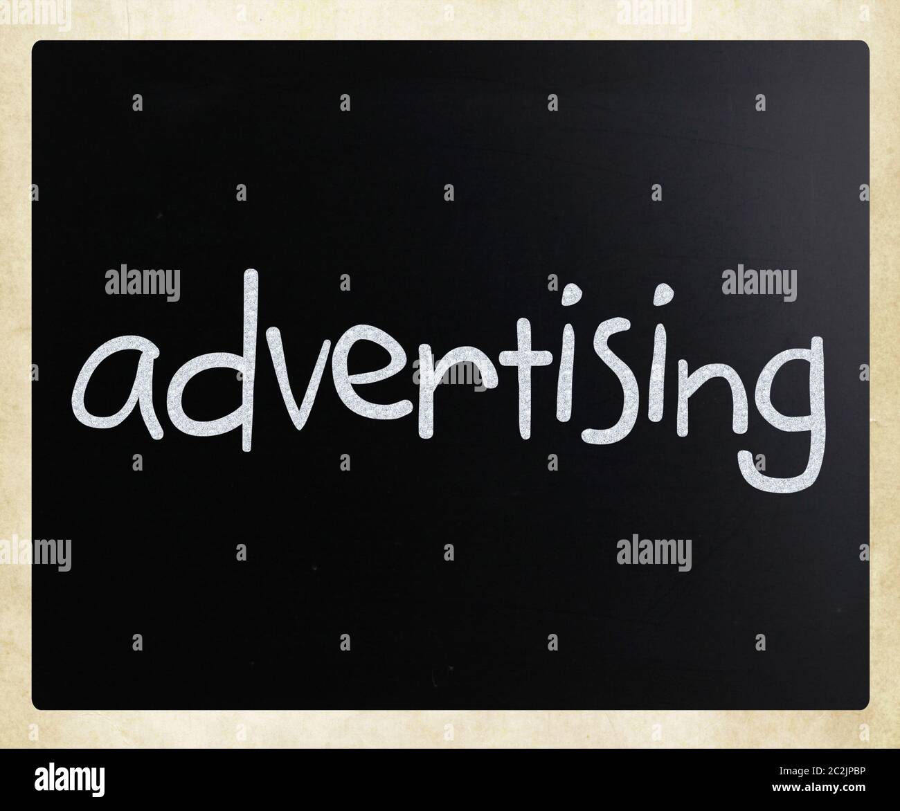 The word "advertising" handwritten with white chalk on a blackboard ...