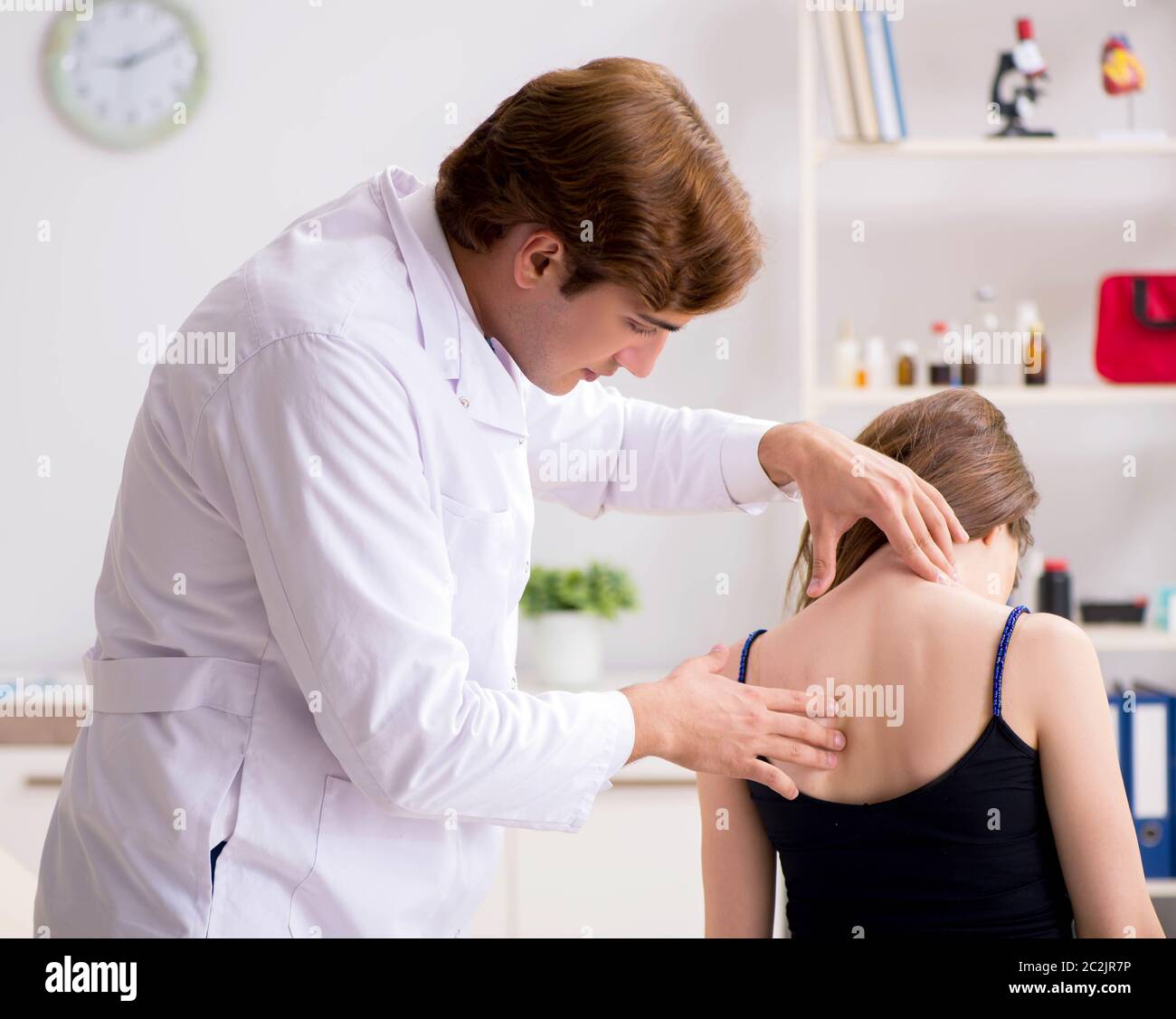 The female patient visiting young handsome doctor chiropractor Stock ...