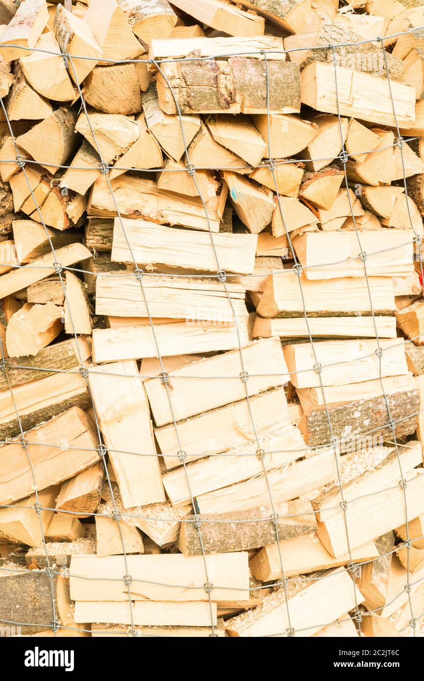 Logs in a metal grid cage on a lumber yard Stock Photo - Alamy
