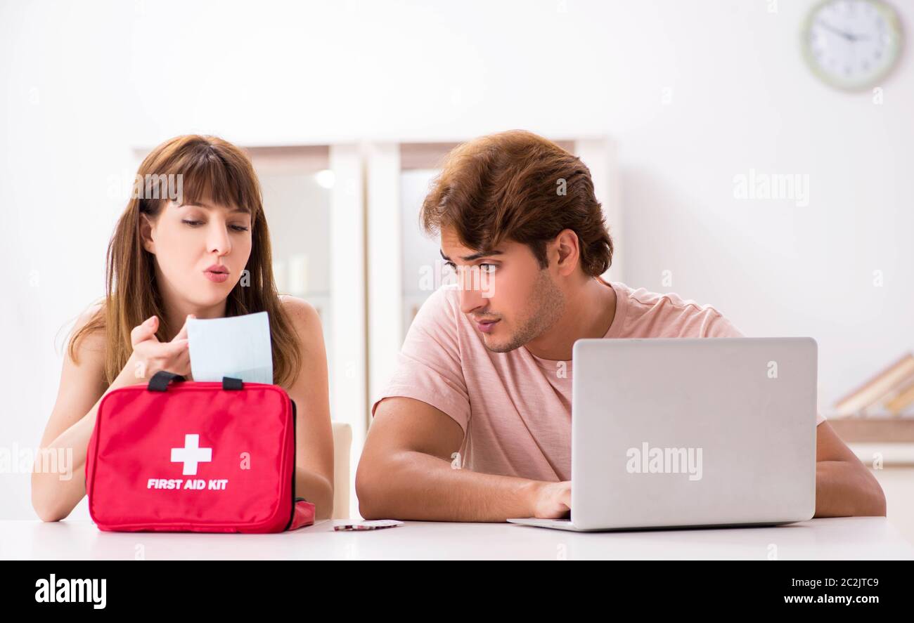 The young family getting treatment with first aid kit Stock Photo - Alamy