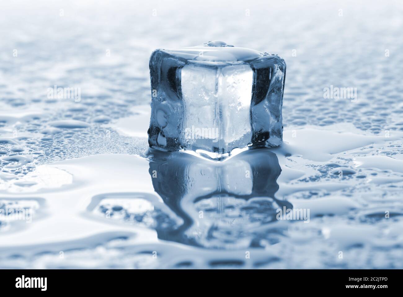 A melting single ice cube with blue tone Stock Photo - Alamy