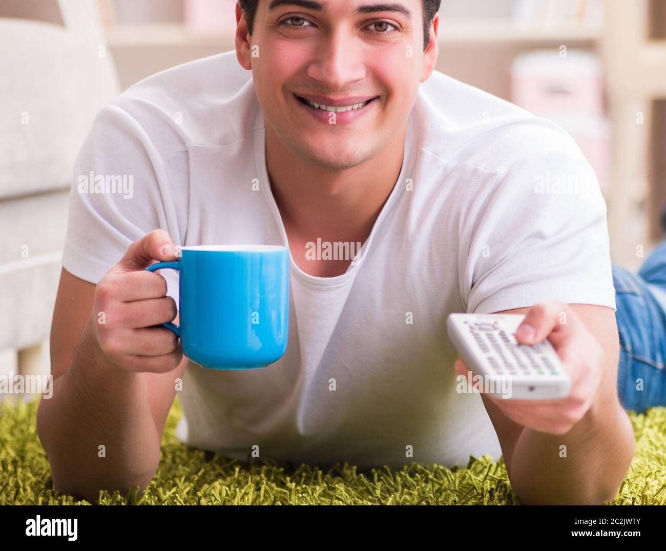Man watching tv at home on floor Stock Photo - Alamy