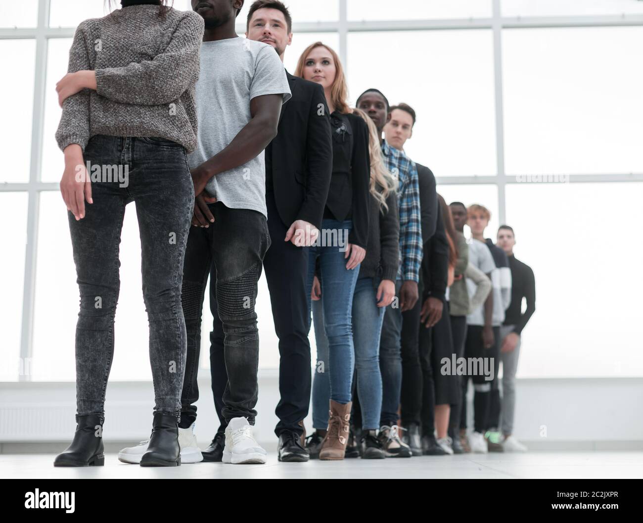 group of diverse young people standing in a queue Stock Photo - Alamy