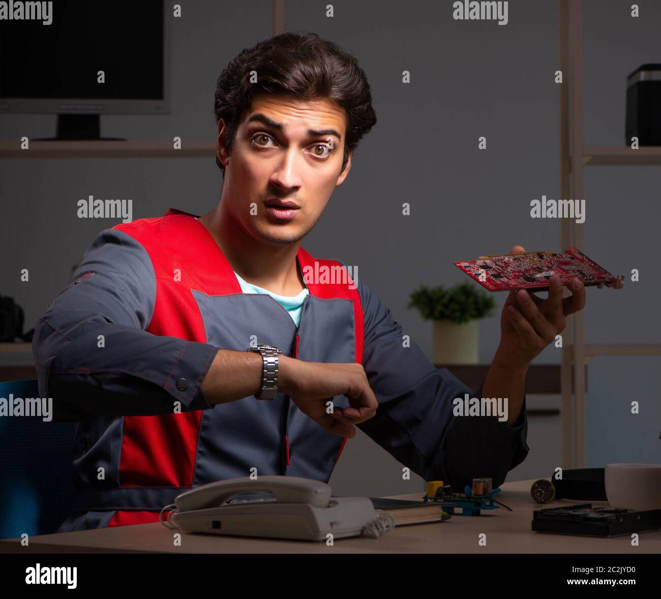 The young handsome repairman repairing computer Stock Photo - Alamy
