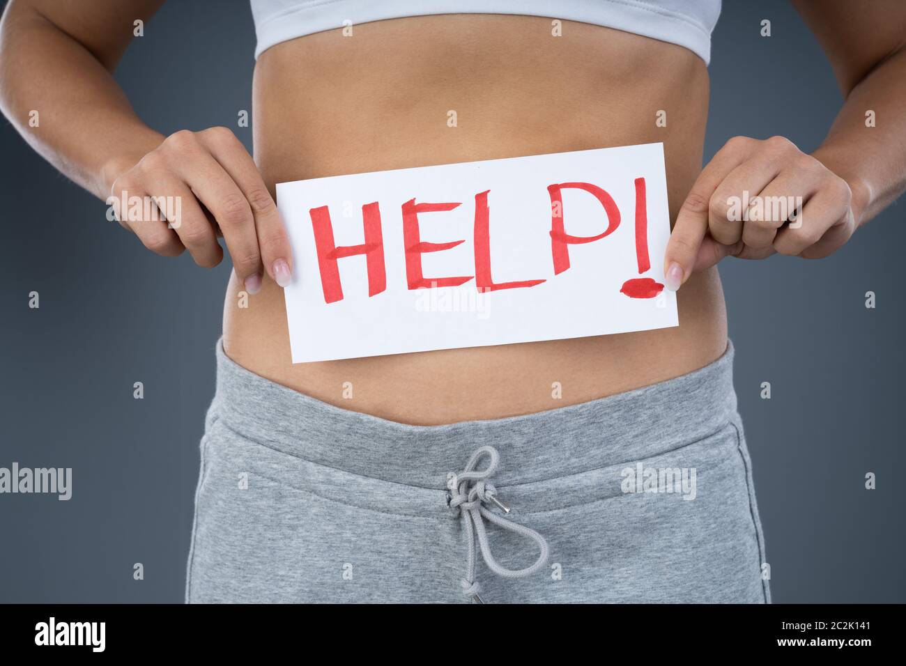 Woman With Stomach Pain Showing Help Sign On Piece Of Paper Stock Photo ...