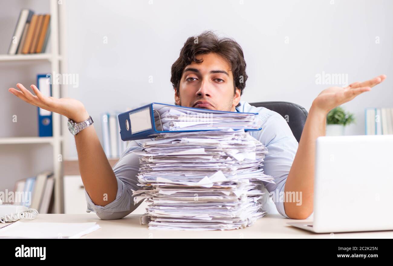 The overloaded busy employee with too much work and paperwork Stock ...