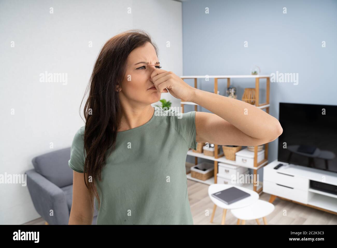 Woman Covering Her Nose From Bad Smell Inside The House Stock Photo - Alamy