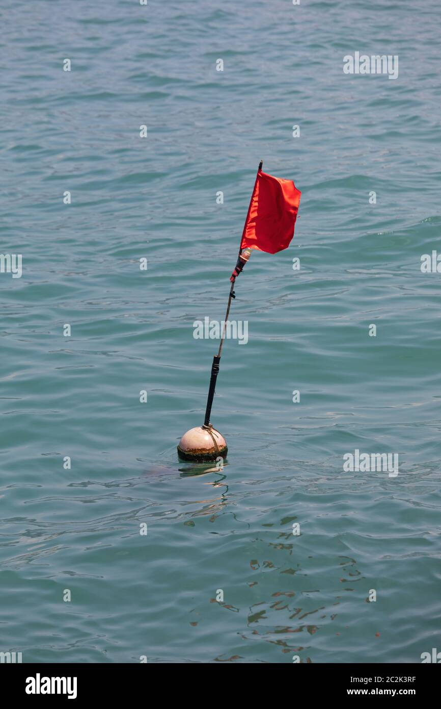Floating Red Flag Mark in Harbour Water Warning Stock Photo - Alamy