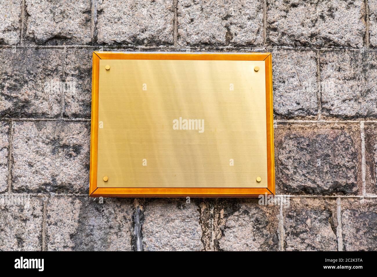 Golden Plaque Board With Frame at Stone Wall Stock Photo - Alamy